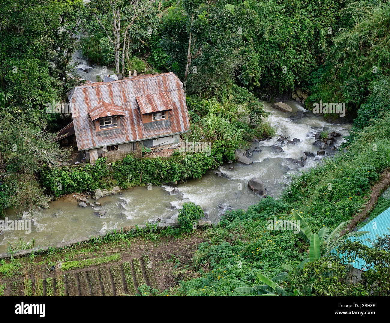 A wooden house with the stream in Banaue, Philippines. Banaue is a town ...