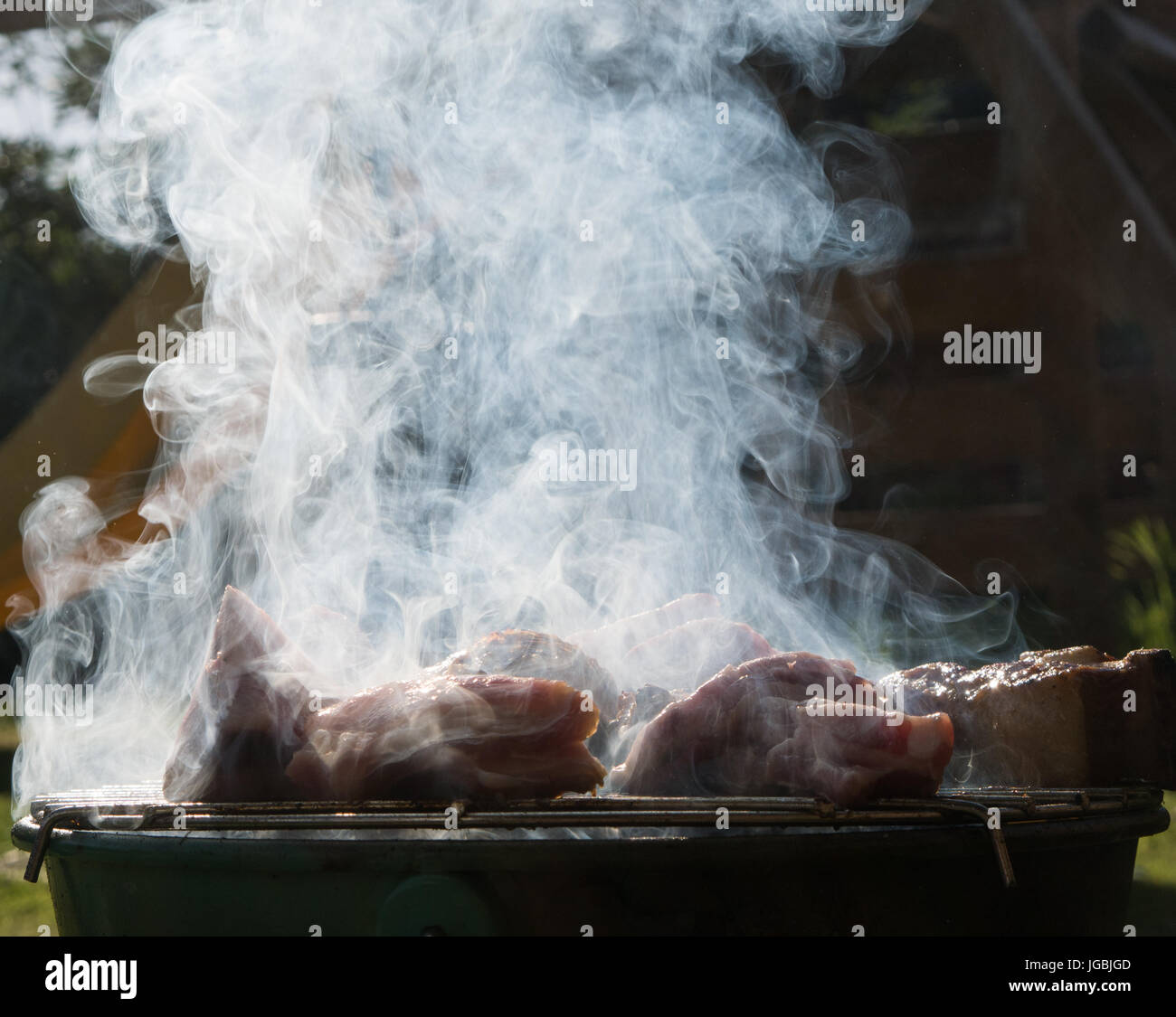 SIzzling meat on barbeque Stock Photo - Alamy