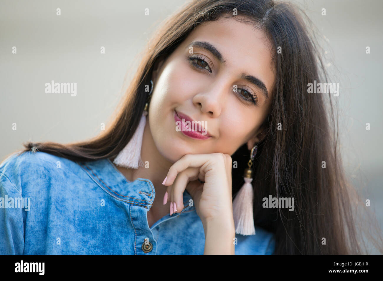 Portrait of a beautiful young Lebanese woman hand touching face smiling ...