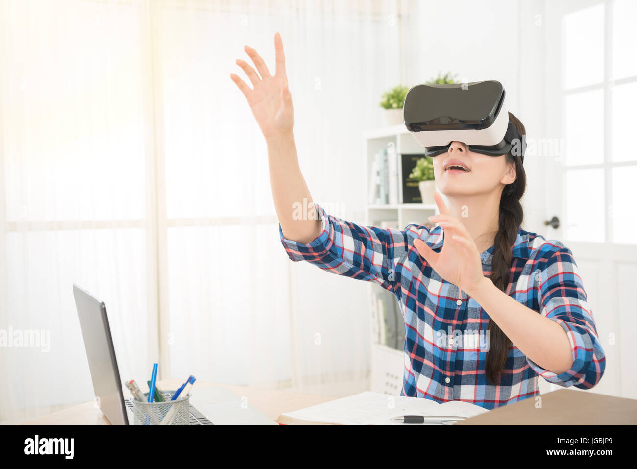 woman in virtual reality headset looking up and trying to touch objects ...
