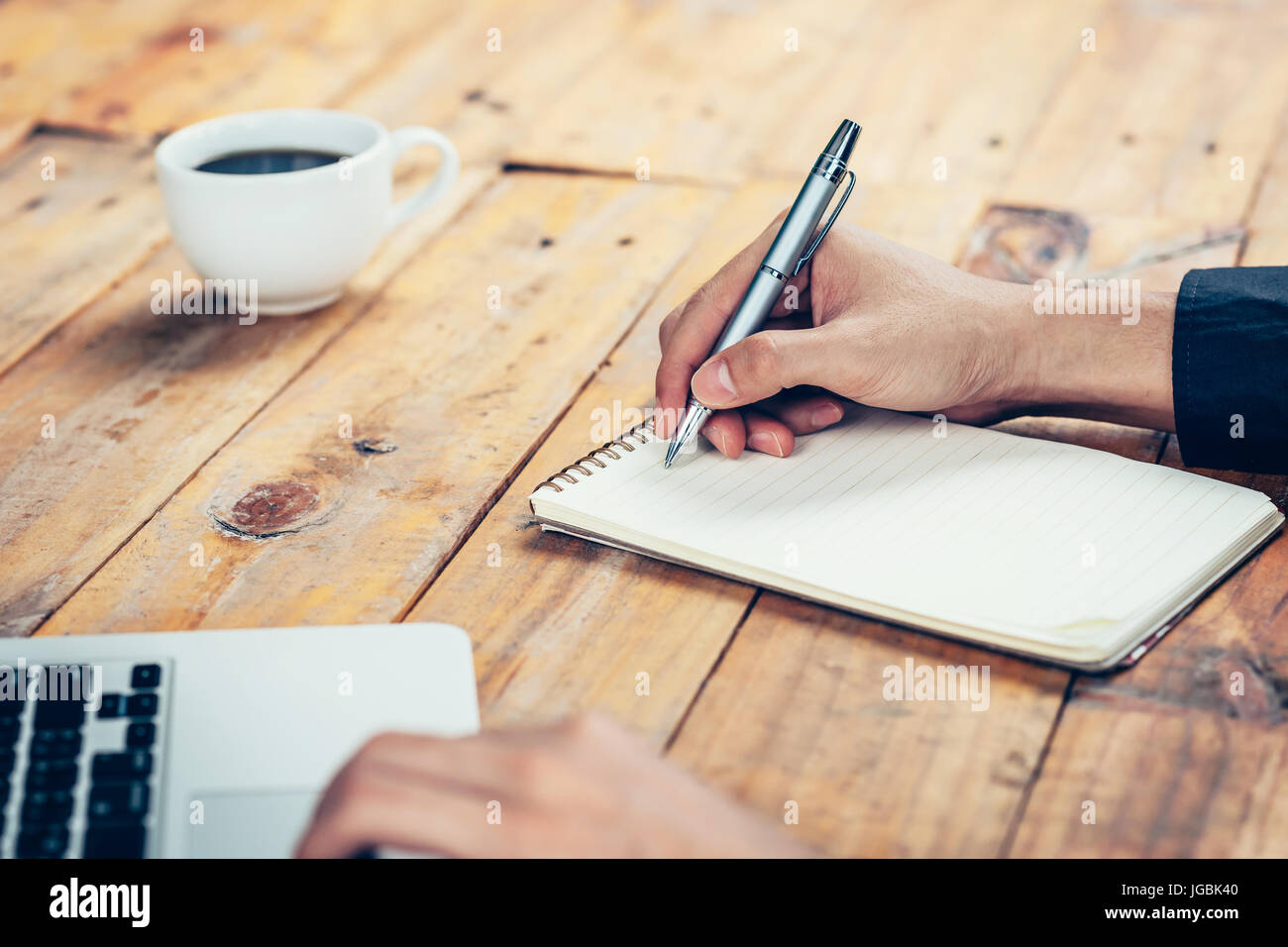 Hand business man writing notebook on wood table in coffee shop Stock ...