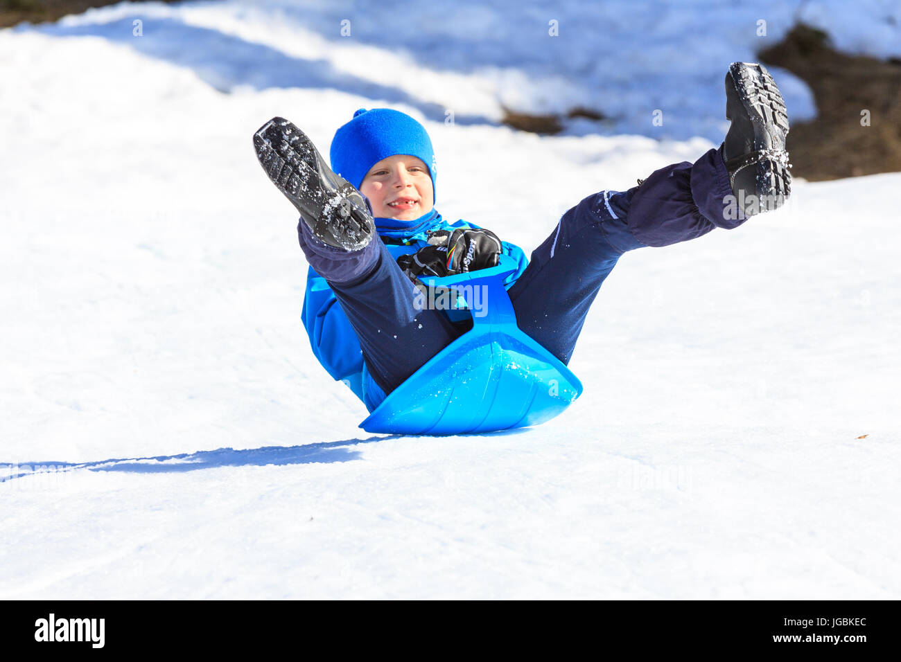 Boy riding a small toboggan, smiling and enoying the hight speed Stock ...