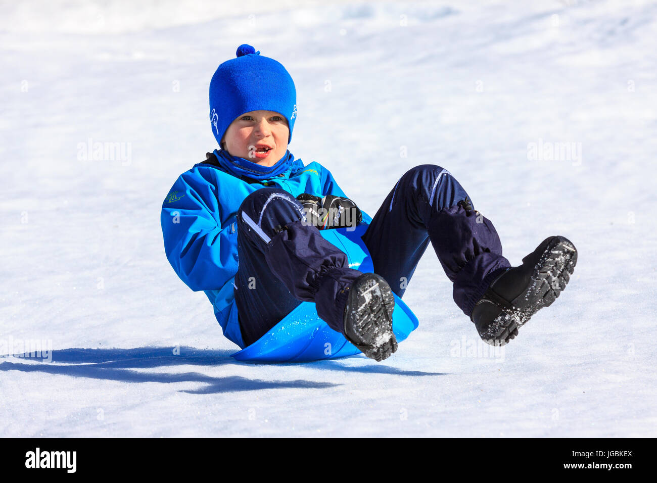 Boy riding a small toboggan, smiling and enoying the hight speed Stock ...