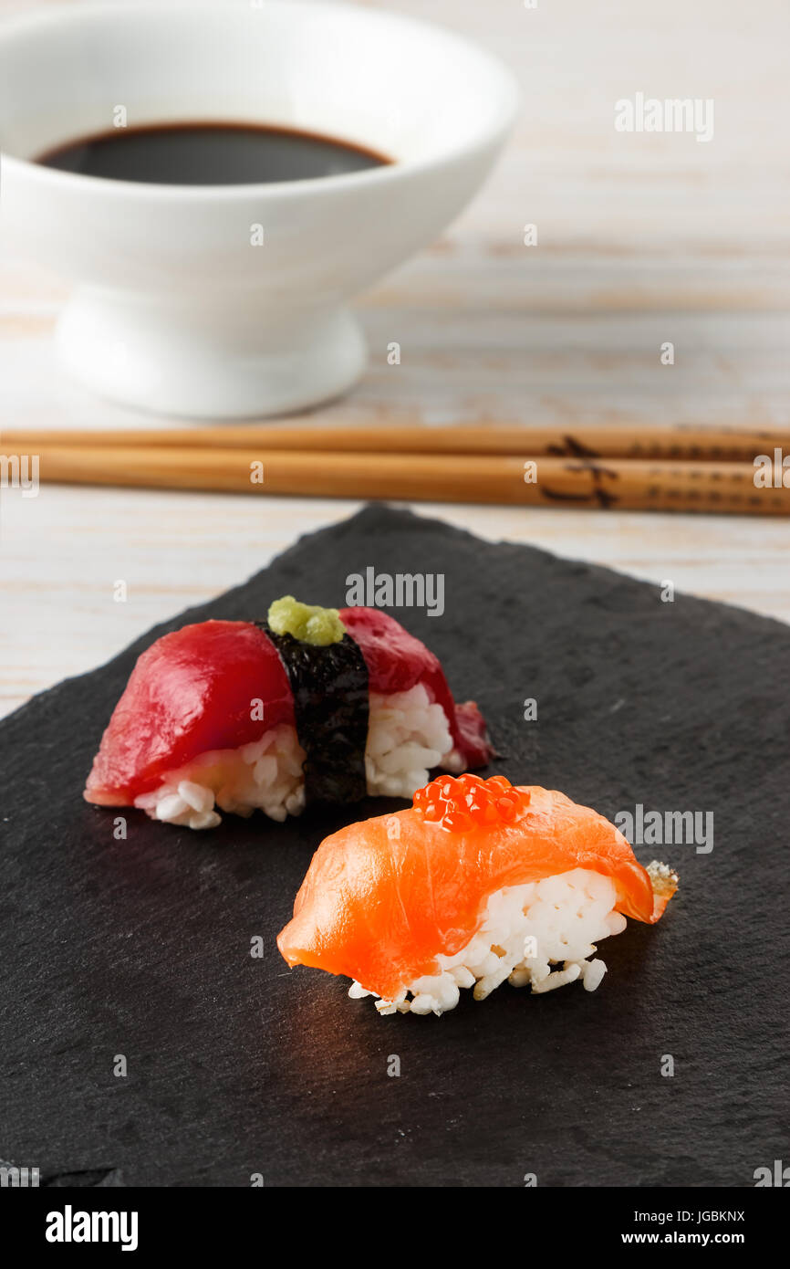 Salmon Nigiri with salmon roe on black slate stone with chopsticks and ...