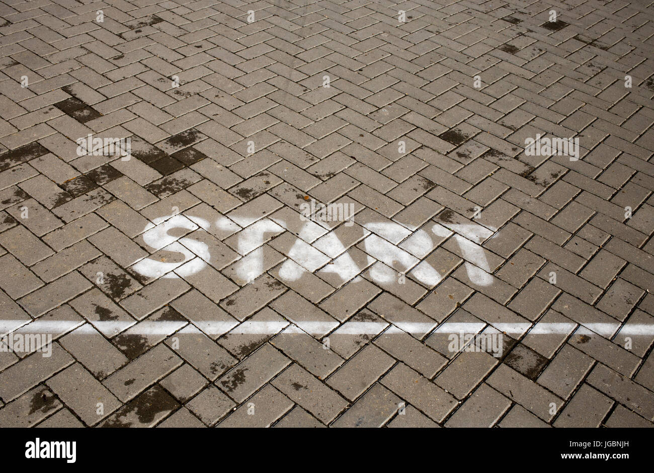 Start your path. Start Word is written in white paint on the sidewalk ...