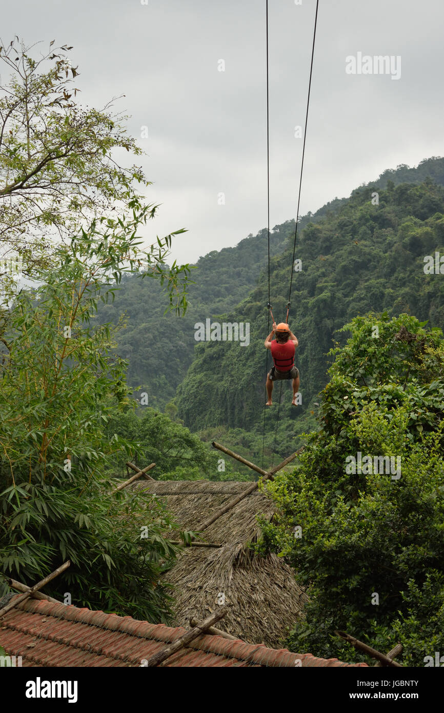 Young woman zip lining hi-res stock photography and images - Alamy