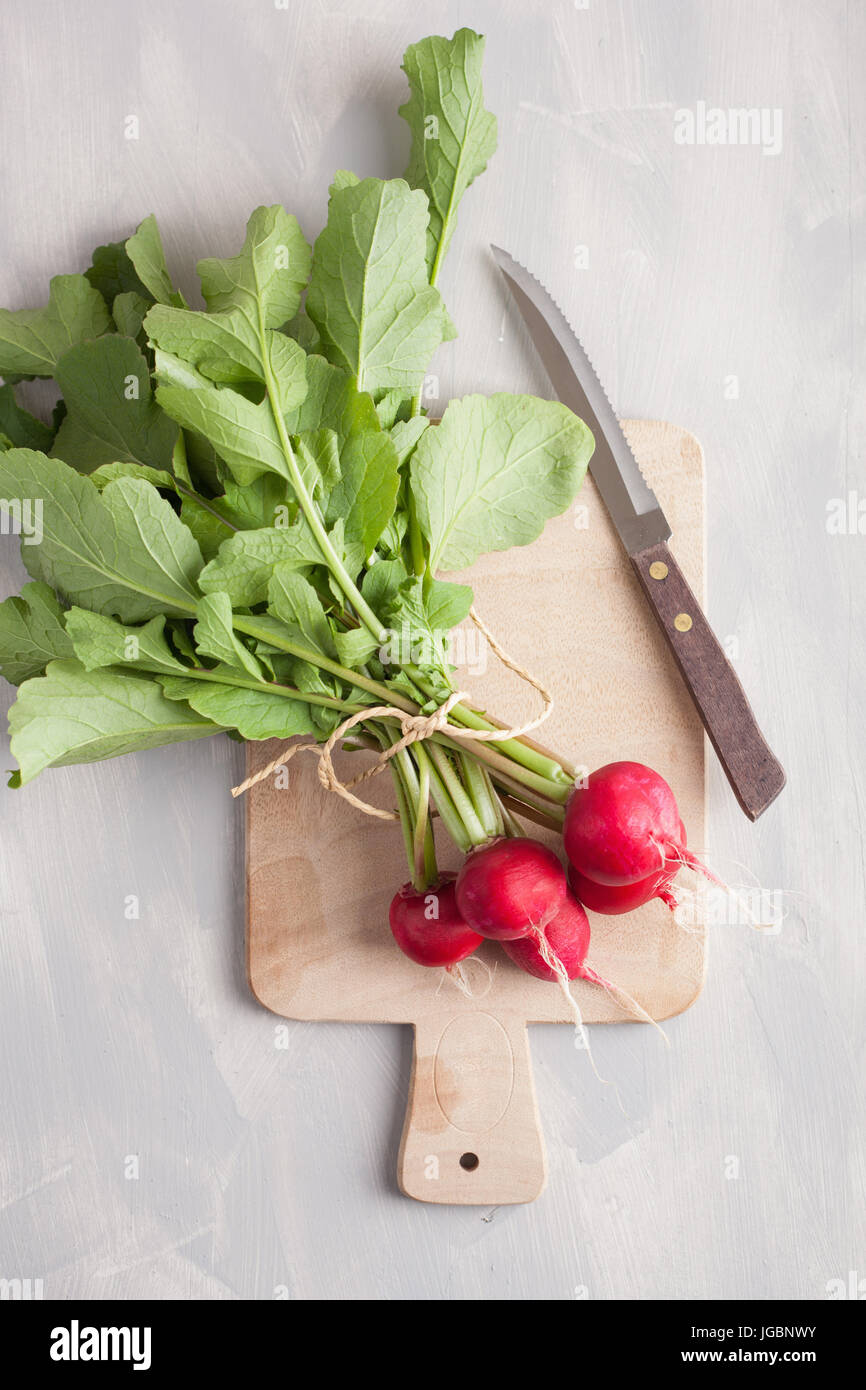 fresh raw radish with leaves over gray background Stock Photo - Alamy