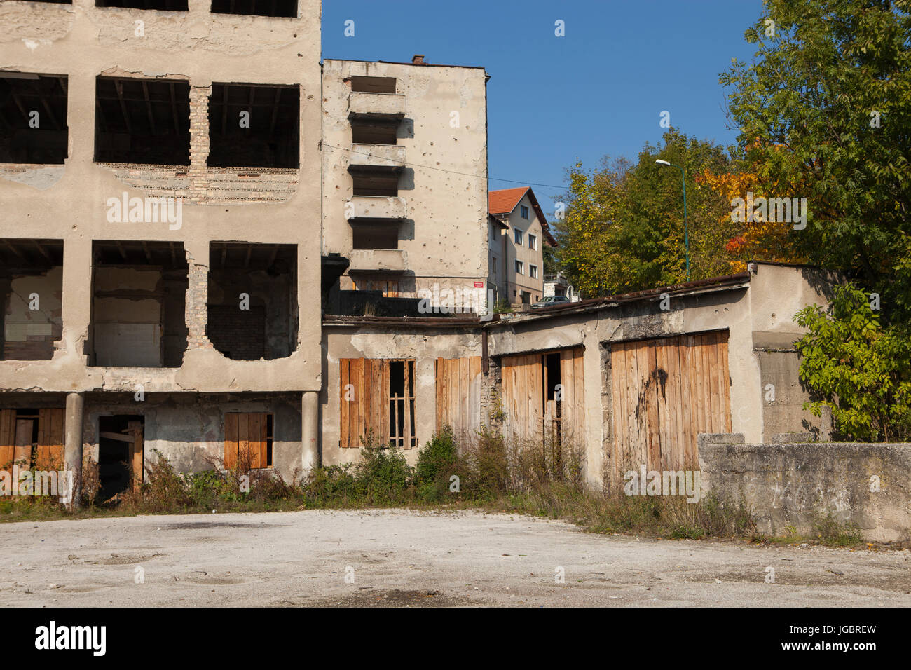Burnt out buildings peppered with bullet holes are still commonly seen ...