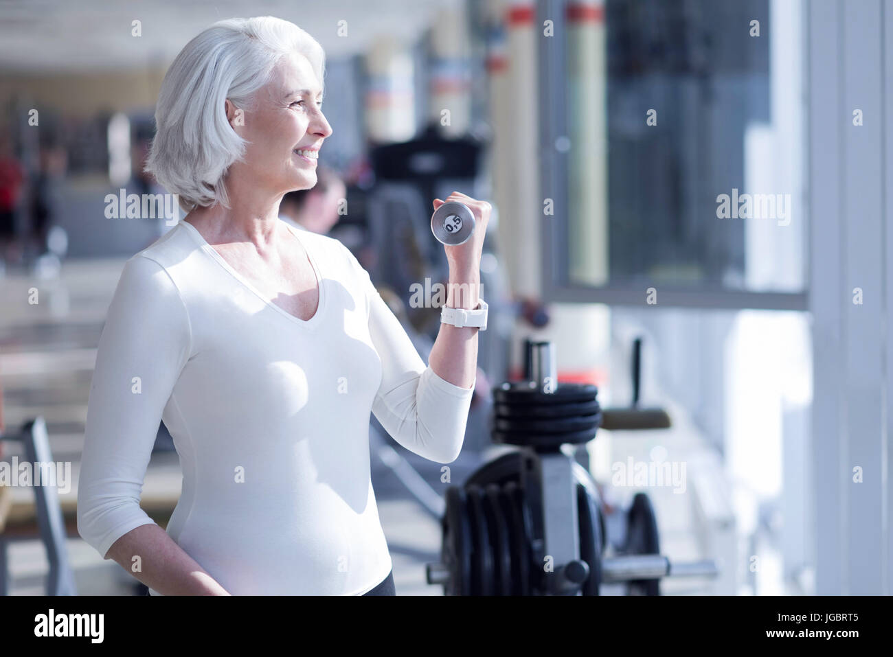 Smiling old lady with dumbbells Stock Photo - Alamy