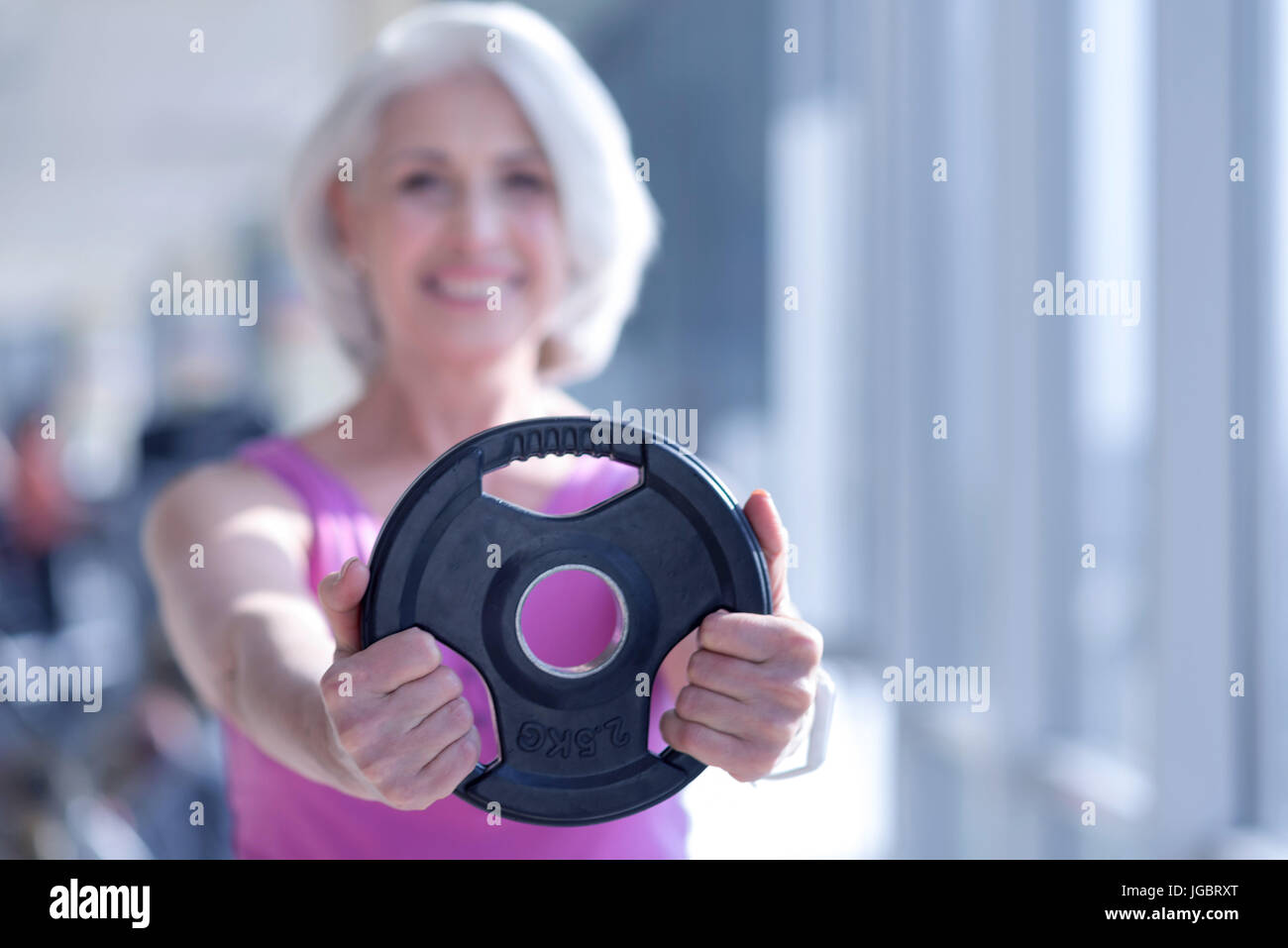 Close-up of senior lady holding barbell Stock Photo - Alamy