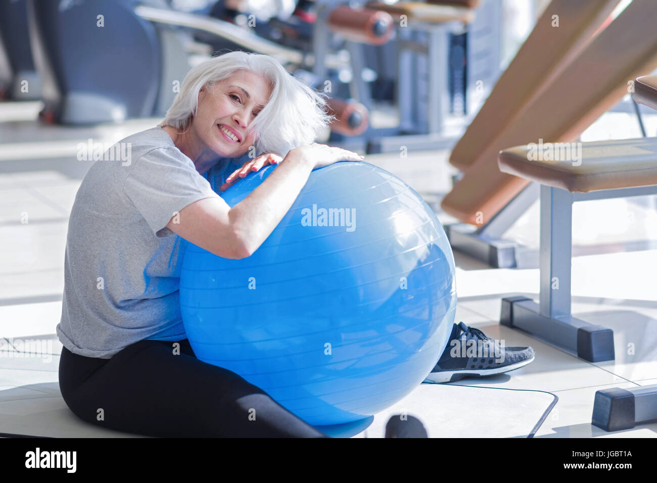 Smiling elderly woman hugging fitness ball Stock Photo - Alamy