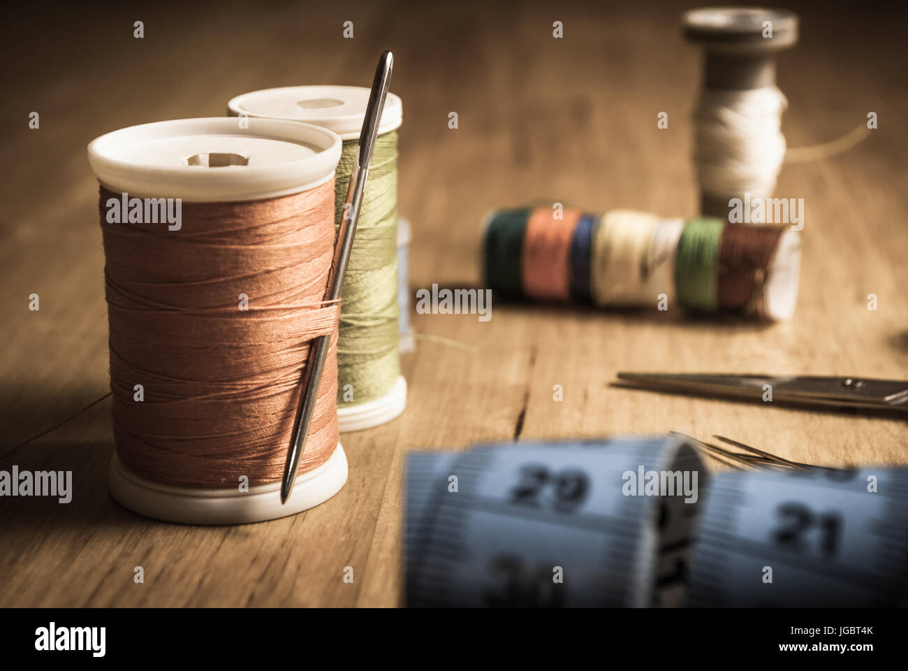 An old style image of cotton reels and other sewing items on a wooden ...