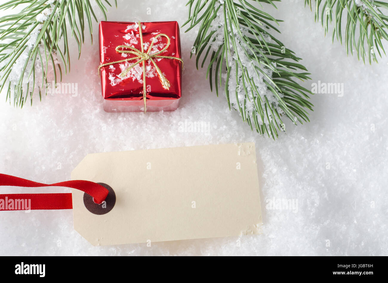 Overhead shot of a small Christmas gift box, with blank parcel tag and ...