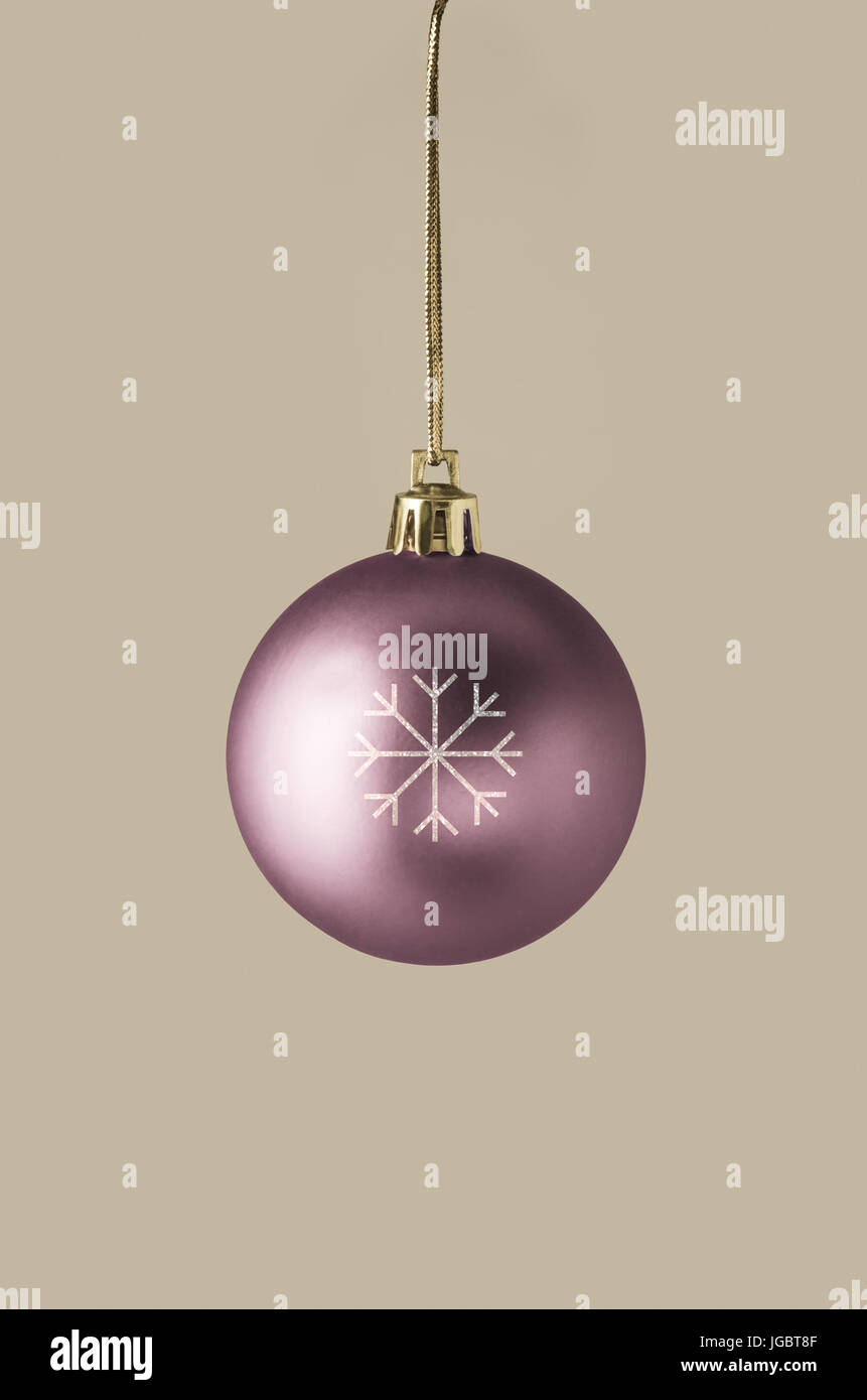 A single bauble in a damson purple hue, hanging from top of frame on a ...