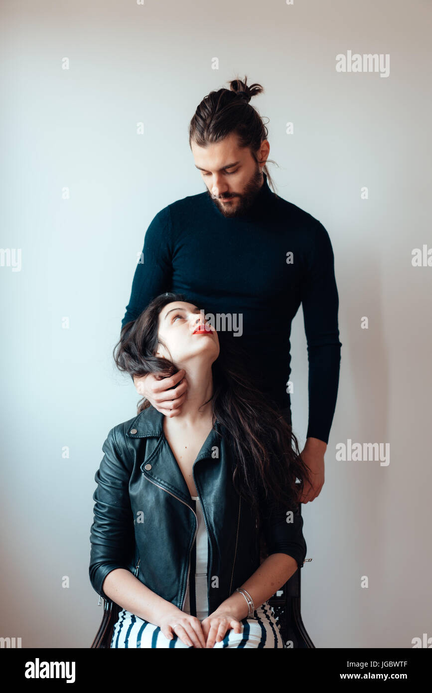 Girl sitting on a chair guy standing behind her Stock Photo - Alamy