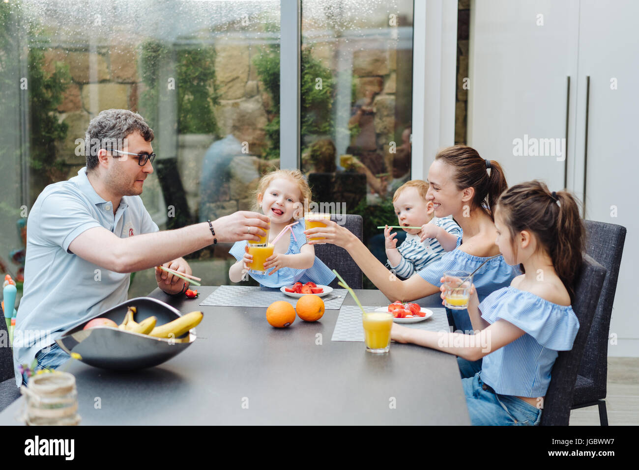 Happy family eating fresh fruit breakfast Stock Photo - Alamy