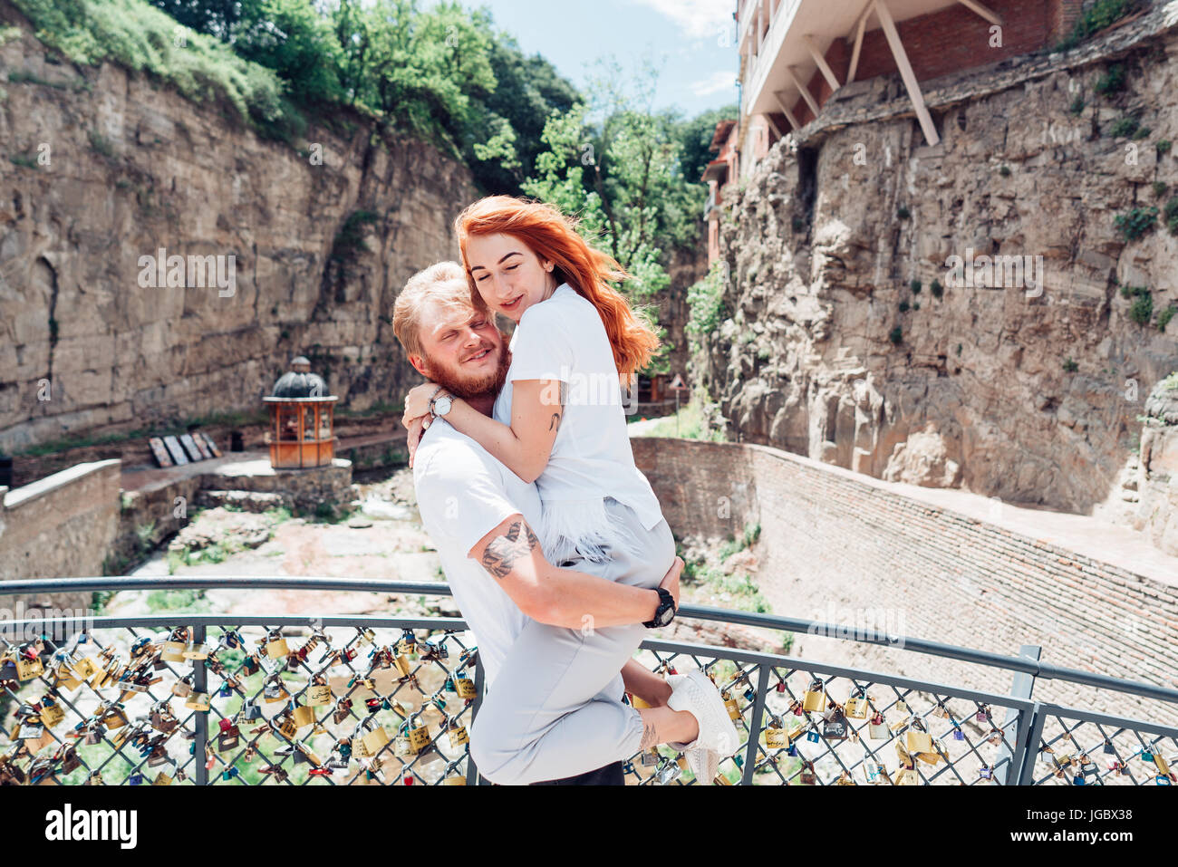Guy with a girl standing on bridge Stock Photo - Alamy