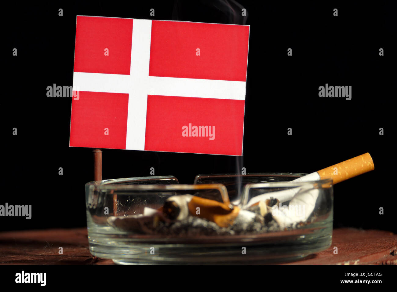 Danish flag with burning cigarette in ashtray isolated on black ...