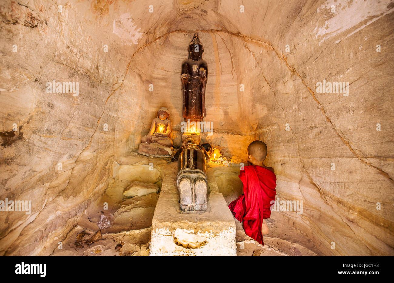 Monk praying with candle light at Po Win Taung / Hpowindaung cave ...