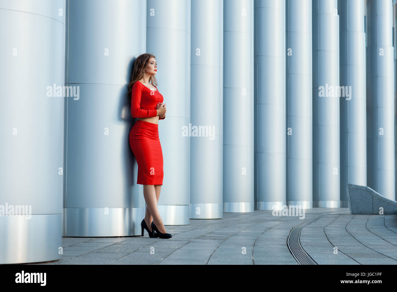 Girl leaned against the column. She is in a trendy red suit Stock Photo ...
