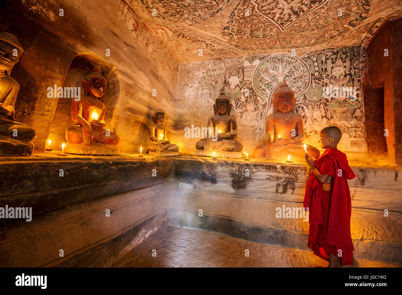 Novice monk praying with candles hi-res stock photography and images ...