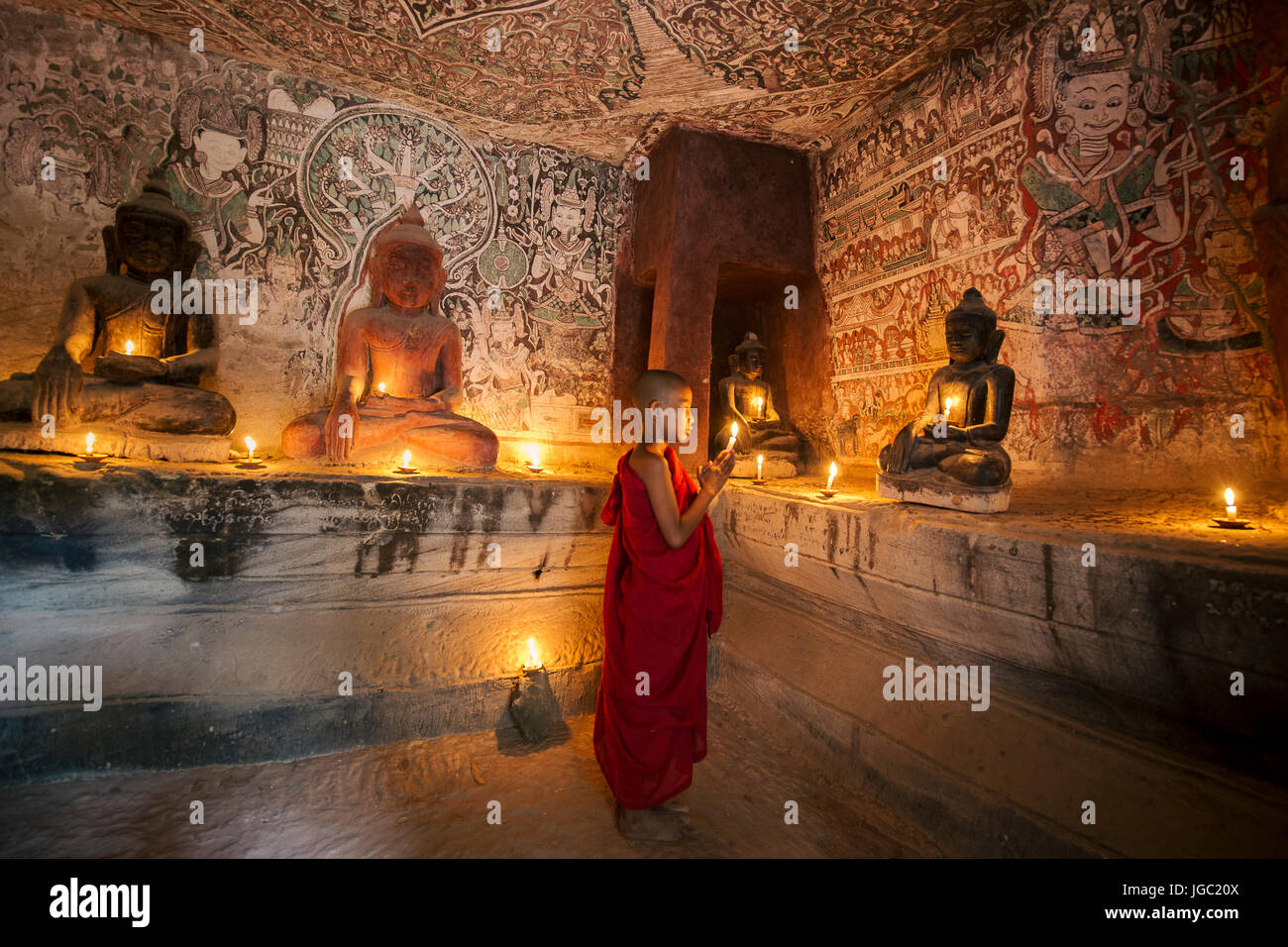 Monk praying with candle light at Po Win Taung / Hpowindaung cave ...