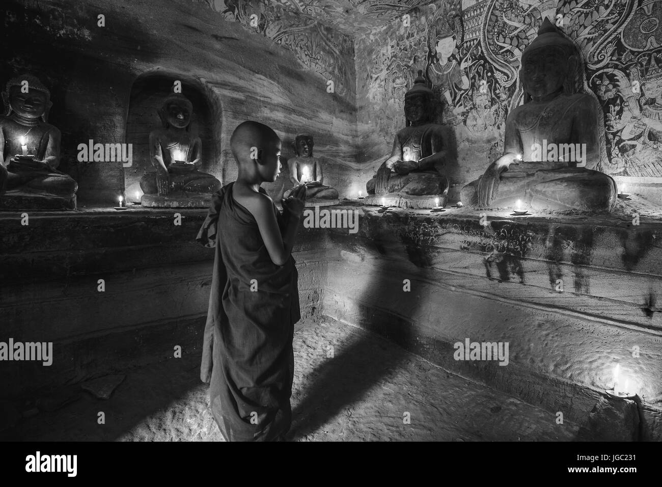 Novice monk praying with candles hi-res stock photography and images ...
