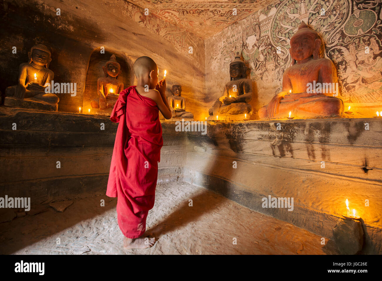 Monk praying with candle light at Po Win Taung / Hpowindaung cave ...