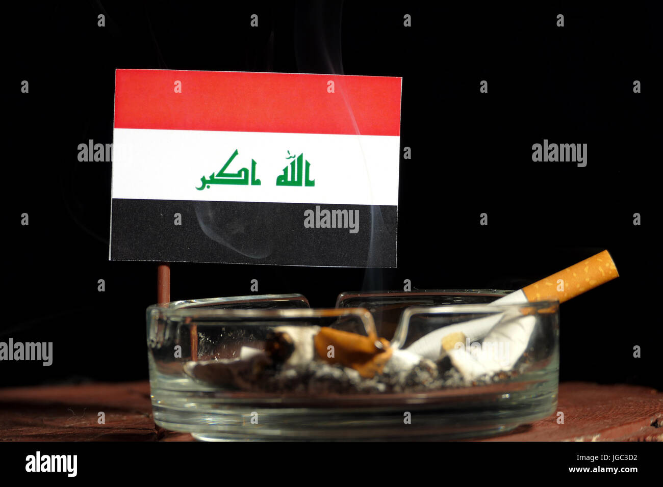 Iraqi flag with burning cigarette in ashtray isolated on black ...