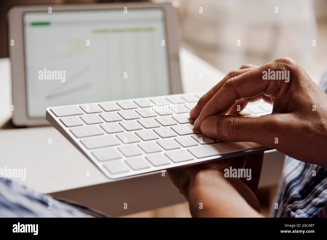 closeup of a young caucasian man in pajamas typing in a computer ...
