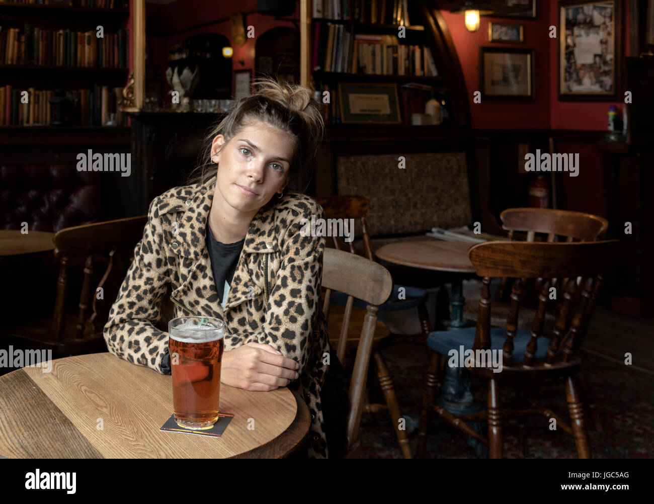 A modern young woman drinking real ale in a London pub Stock Photo - Alamy