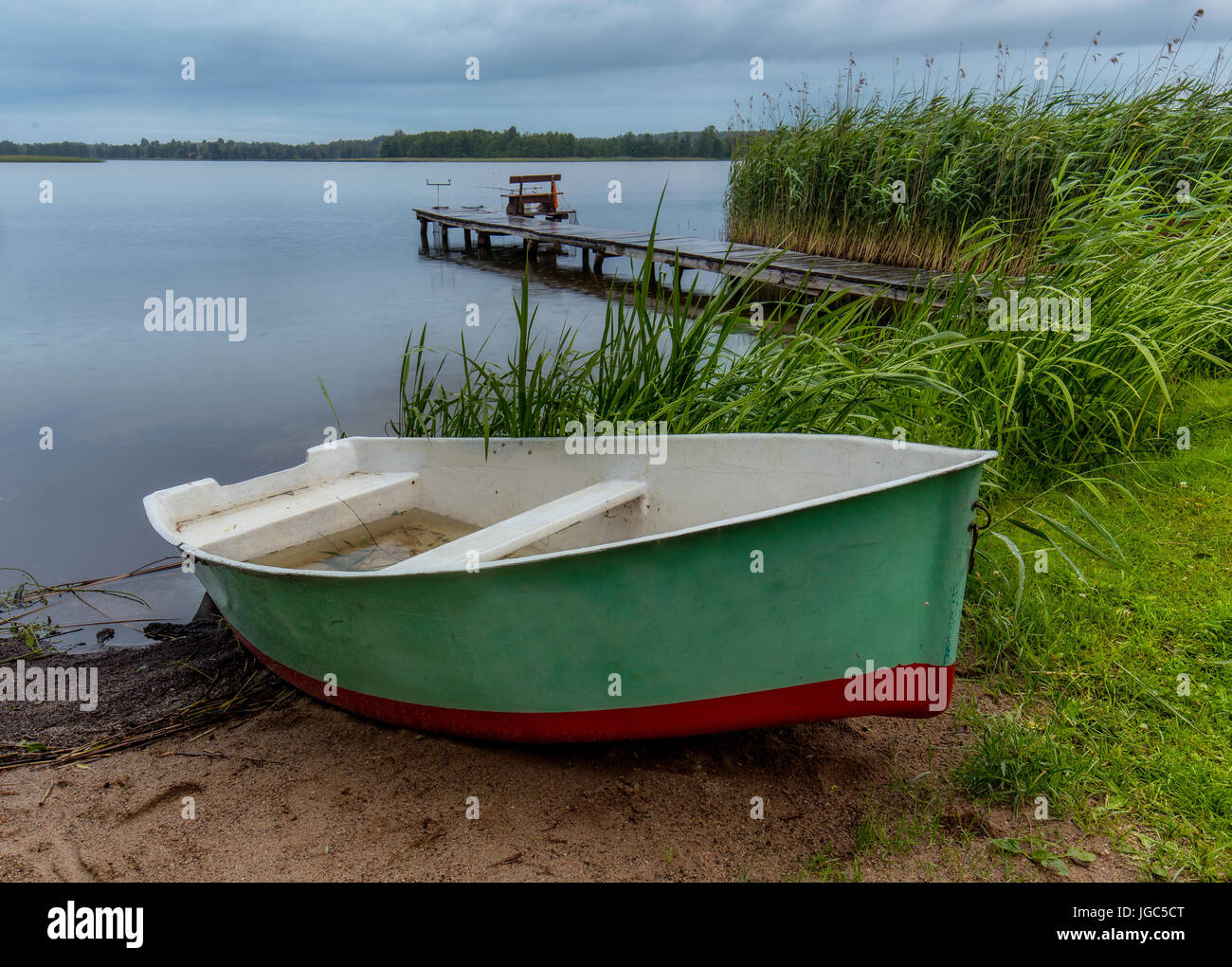 Fisherman's boat on the beach during rain in the evening on Masuria ...