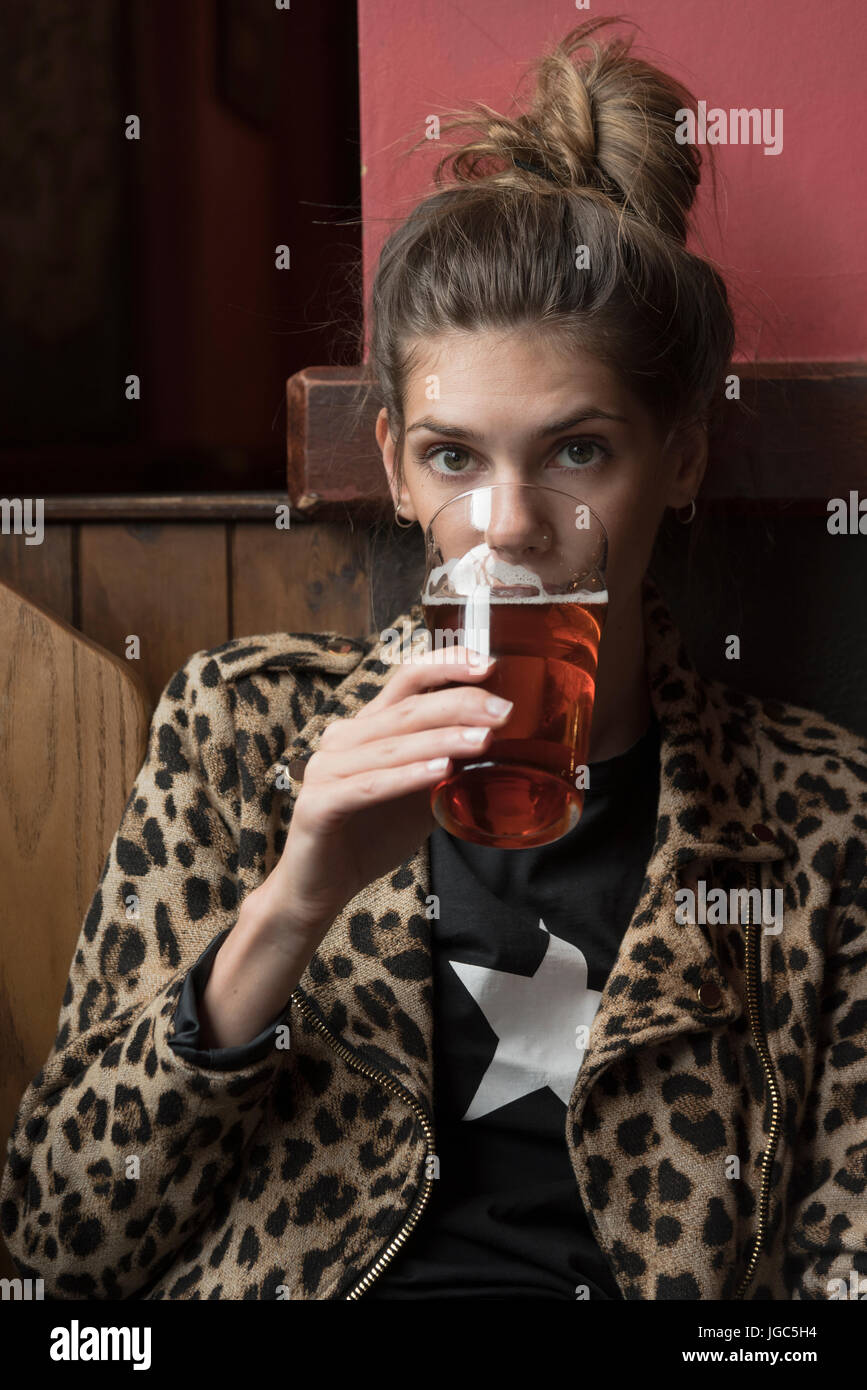A modern young woman drinking real ale in a London pub Stock Photo - Alamy