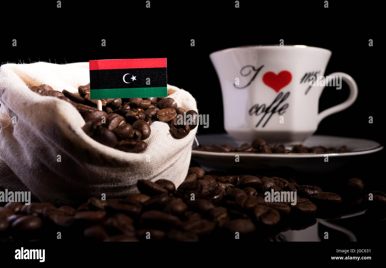 Libyan flag in a bag with coffee beans isolated on black background ...