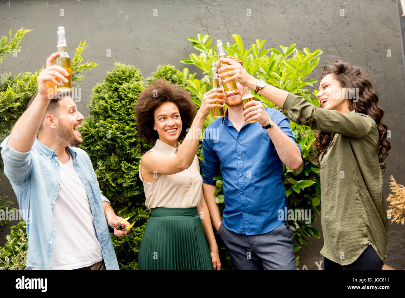 Group Of Friends Having Outdoor Garden Party Toast With Alcoholic Cider