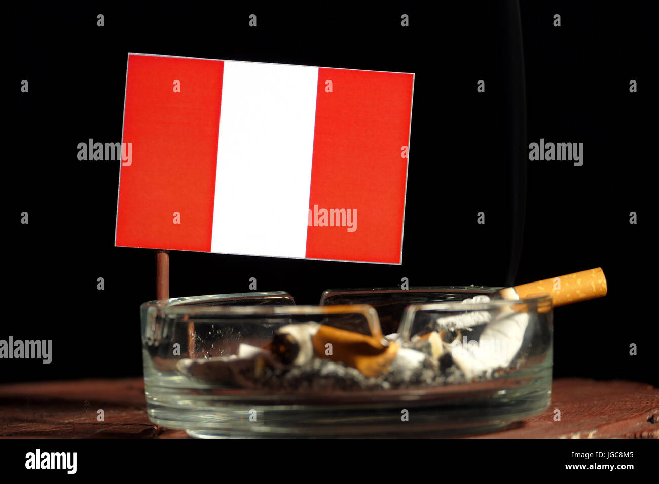 Peruvian flag with burning cigarette in ashtray isolated on black ...