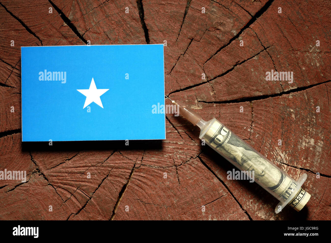 flag on a stump with syringe injecting money in flag Stock Photo - Alamy