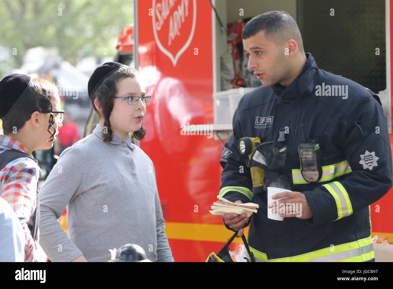 Hackney. London. 5 July 2017 - Children talking to the fireman ...