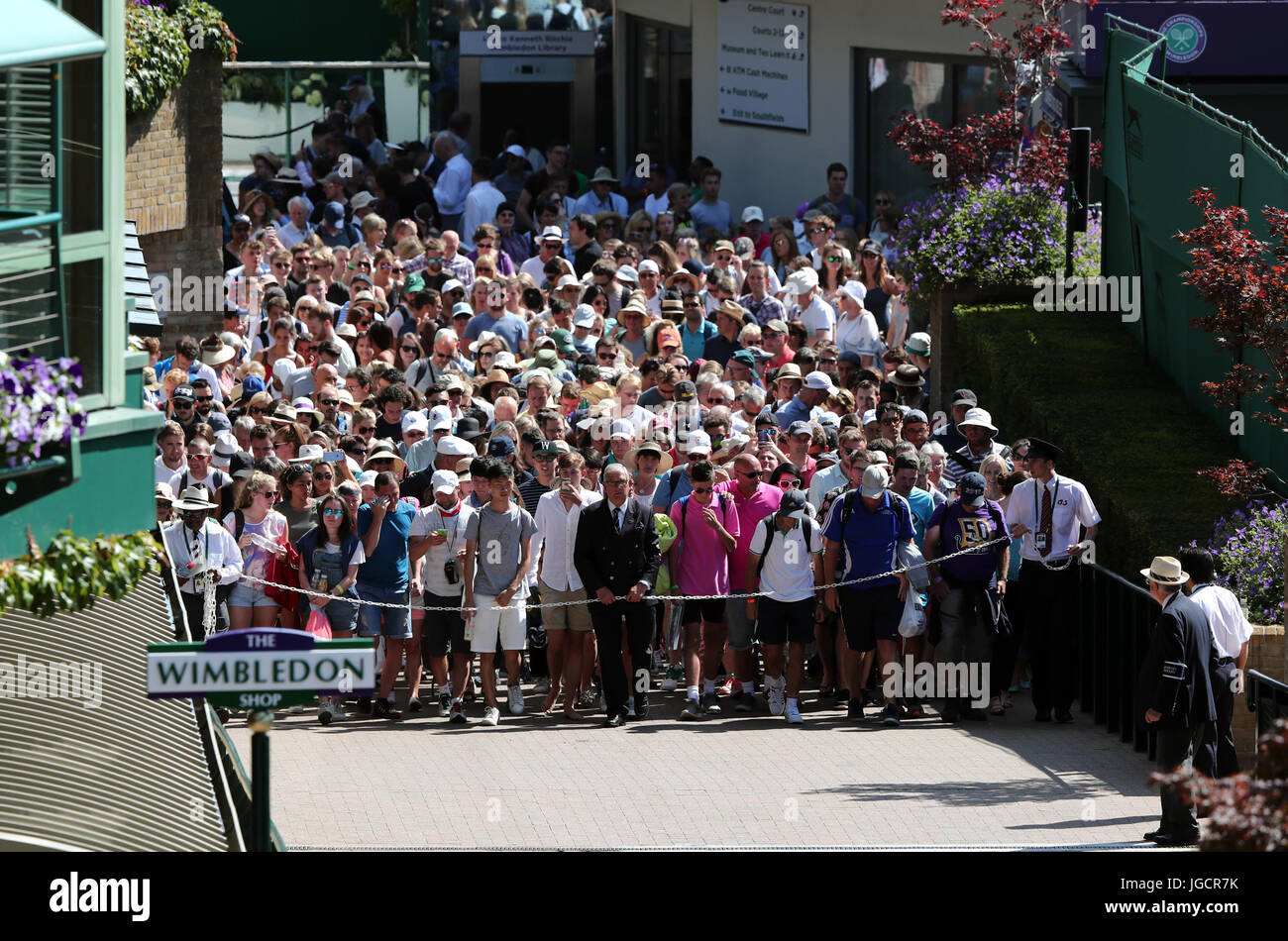Spectators are led in on day three of the Wimbledon Championships at ...