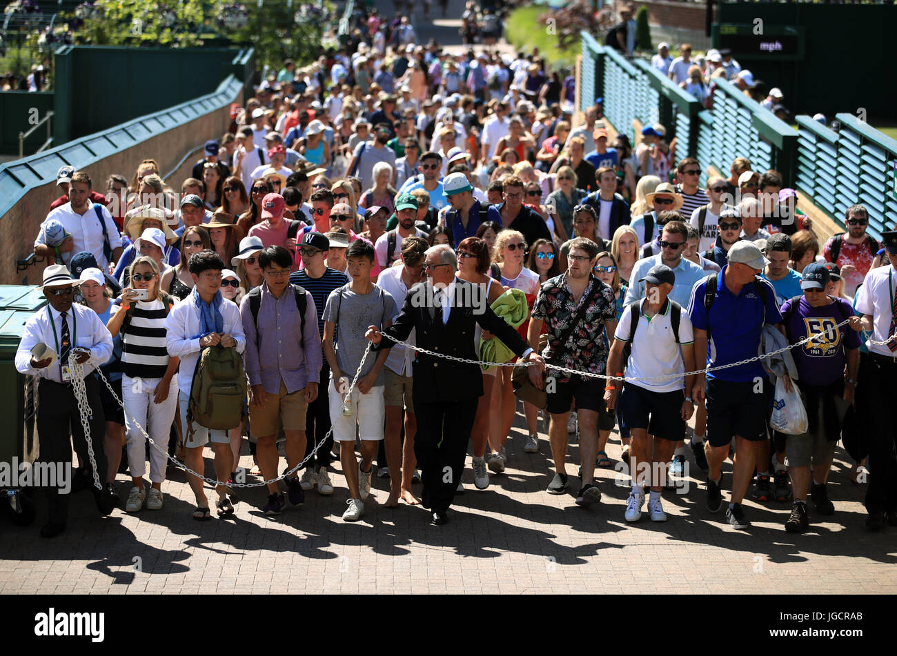 Spectators are led in on day three of the Wimbledon Championships at ...