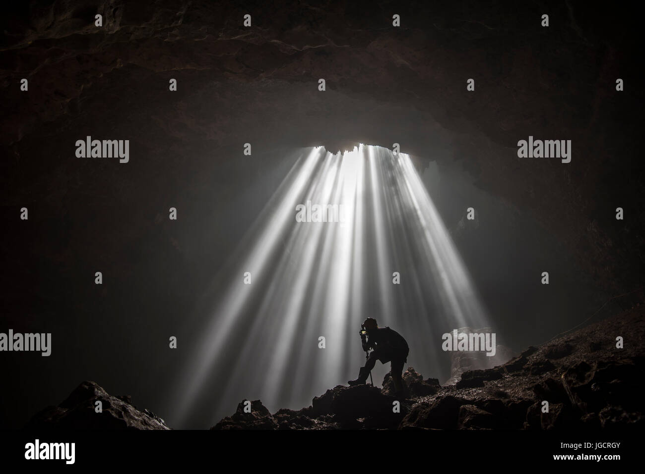 Silhouette of a man taking a photograph, Jomblang cave, Central Java ...
