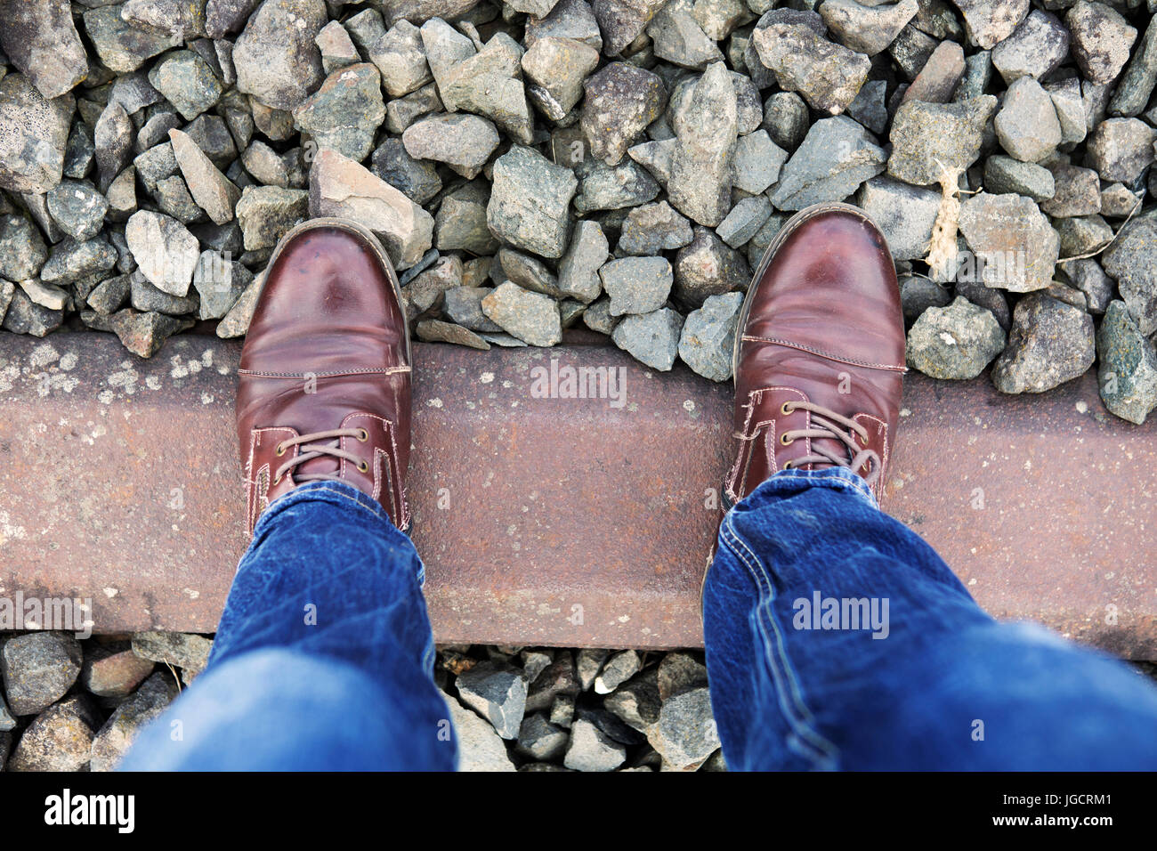 closeup of man standing on train tracks with stones Stock Photo - Alamy