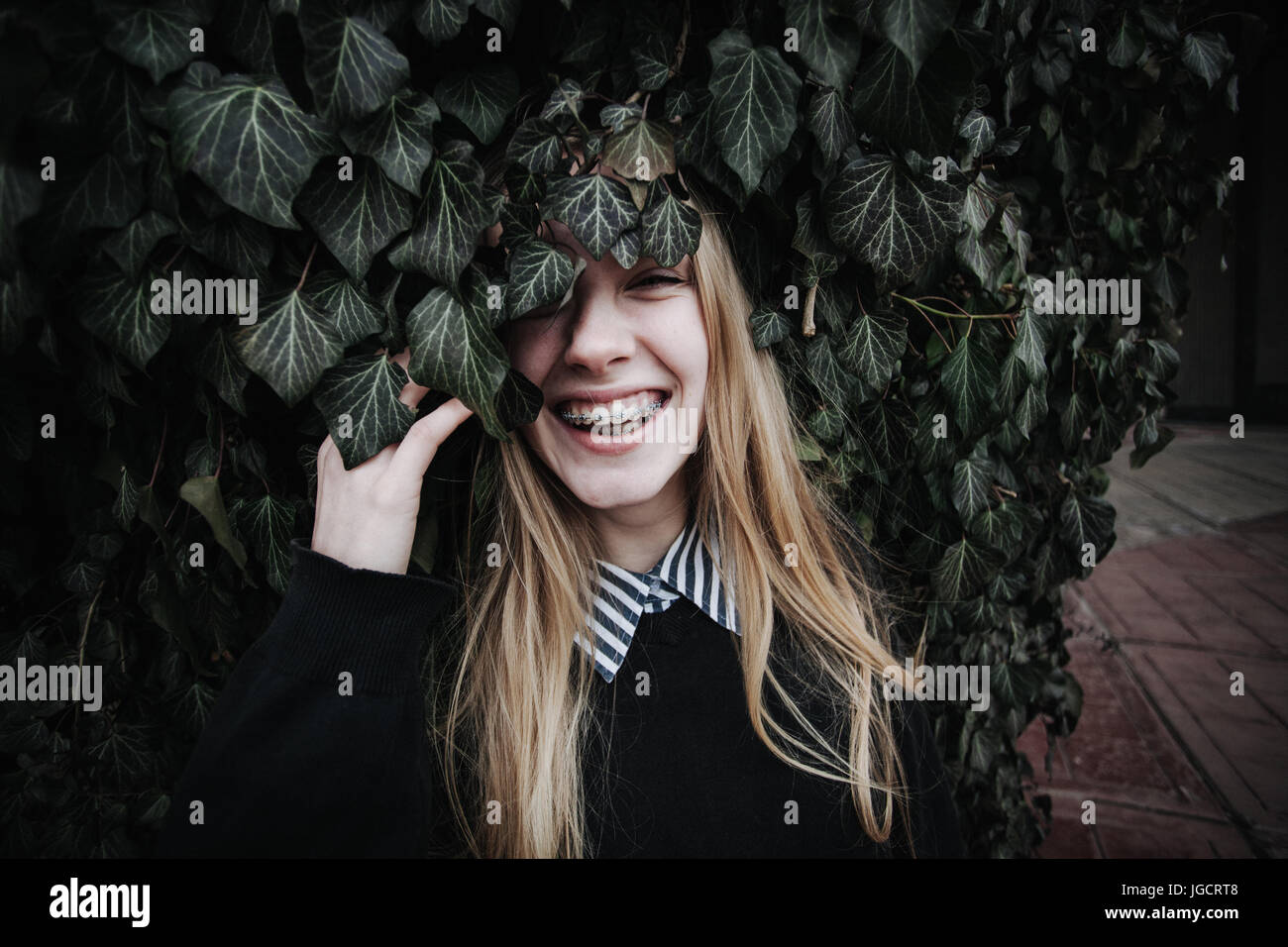 Young woman hiding behind bush hi-res stock photography and images - Alamy