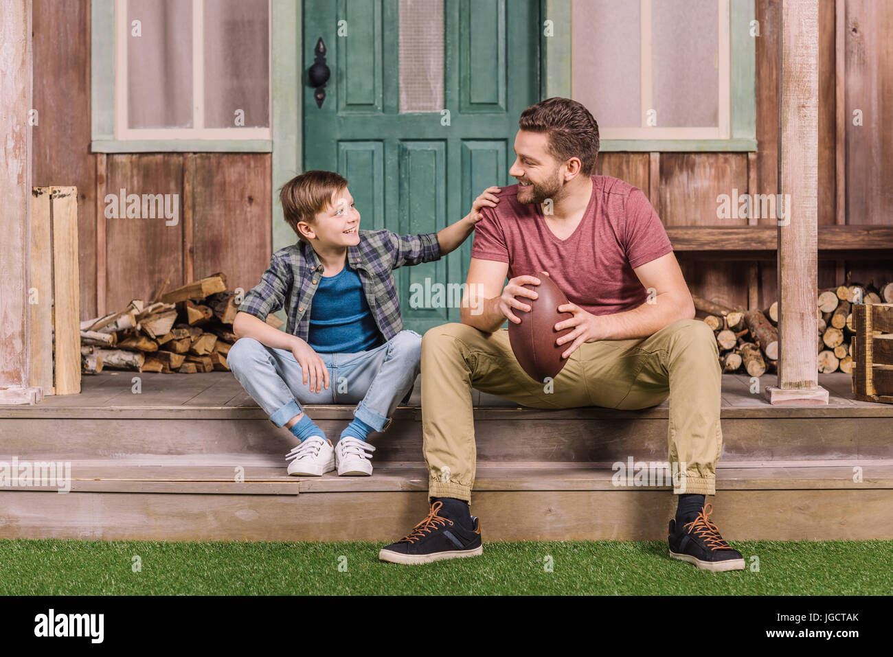young father with little son sitting on porch at backyard, dad and son ...