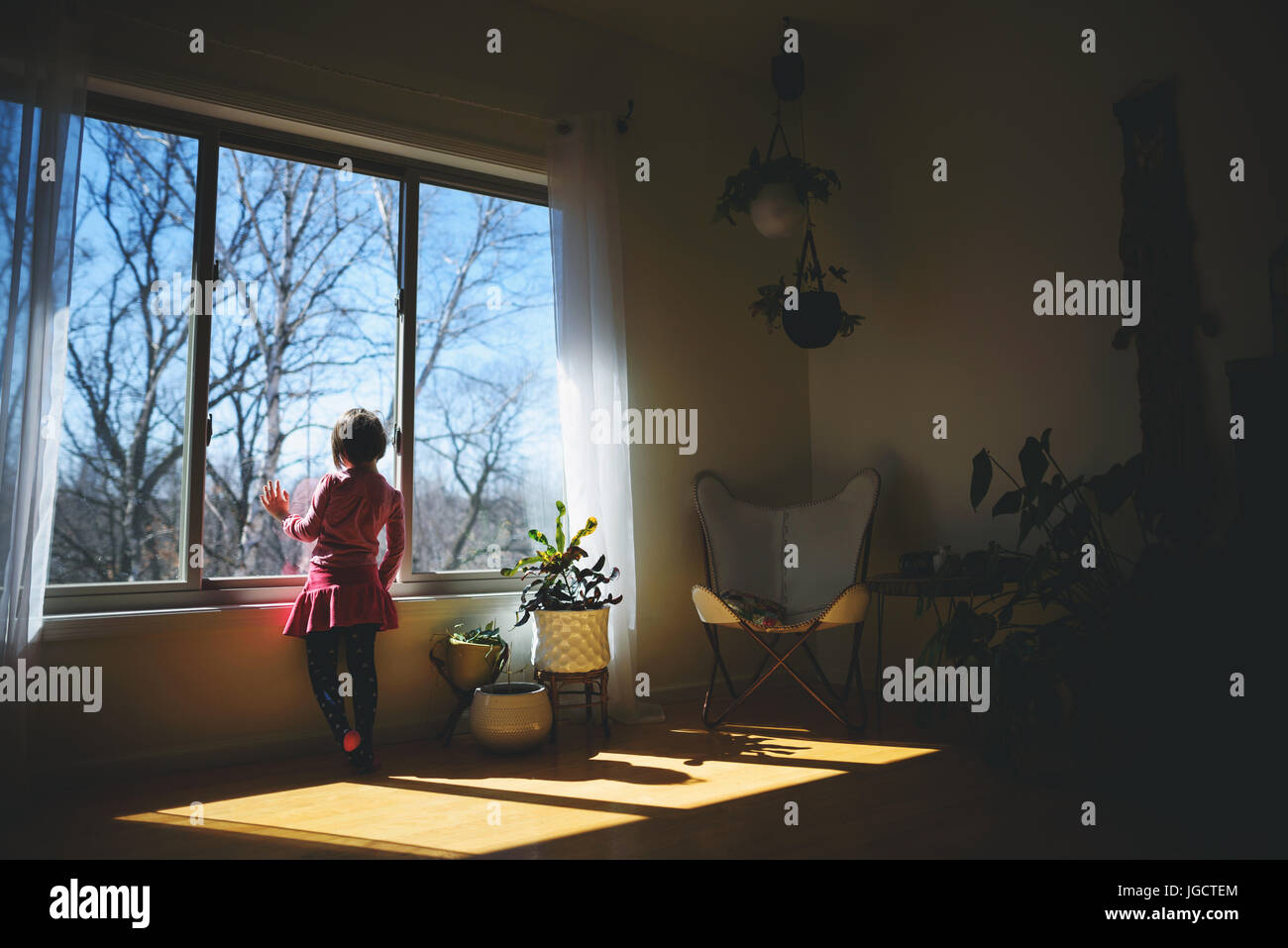 Girl looking through a window Stock Photo - Alamy