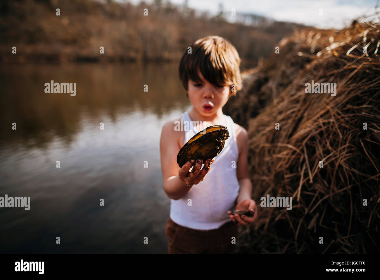 Boy on the beach holding a clam Stock Photo - Alamy