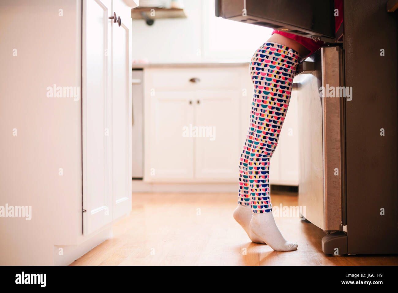 Girl looking for food in an open refrigerator in the kitchen Stock ...