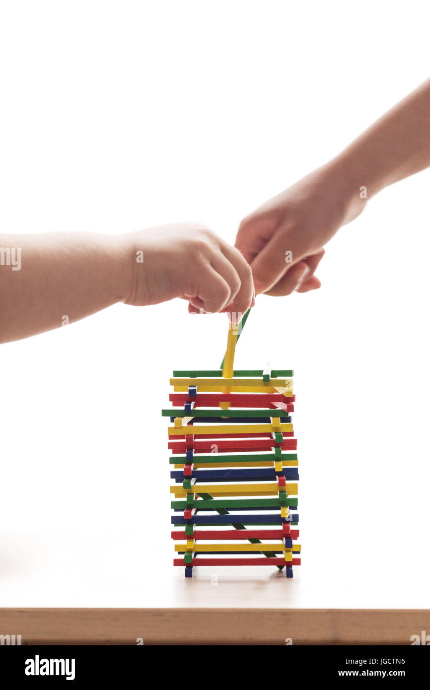 Two boys building a tower with colorful wooden sticks Stock Photo - Alamy