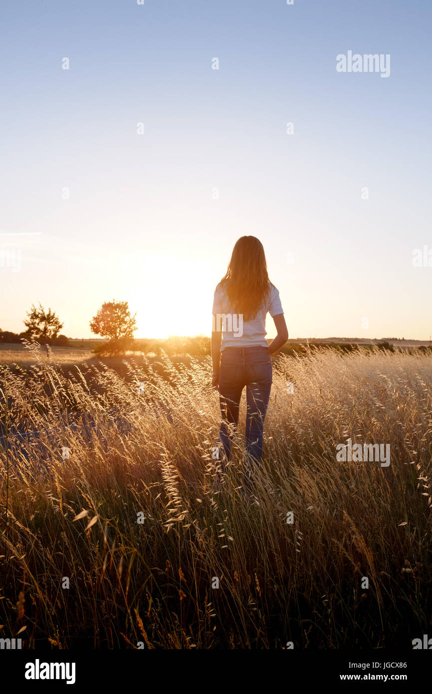 Girl standing in a meadow at sunset, Niort, France Stock Photo - Alamy