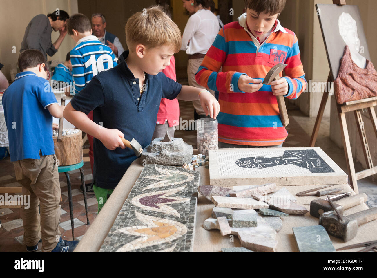 Kids learning how to make a stone mosaic Stock Photo - Alamy